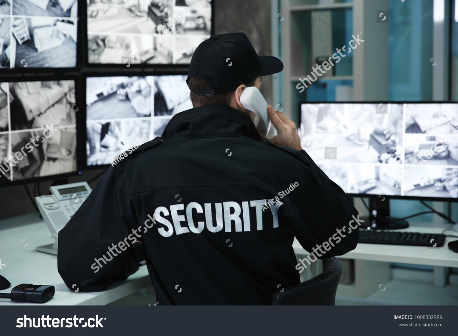 stock-photo-male-security-guard-talking-by-telephone-in-surveillance ...